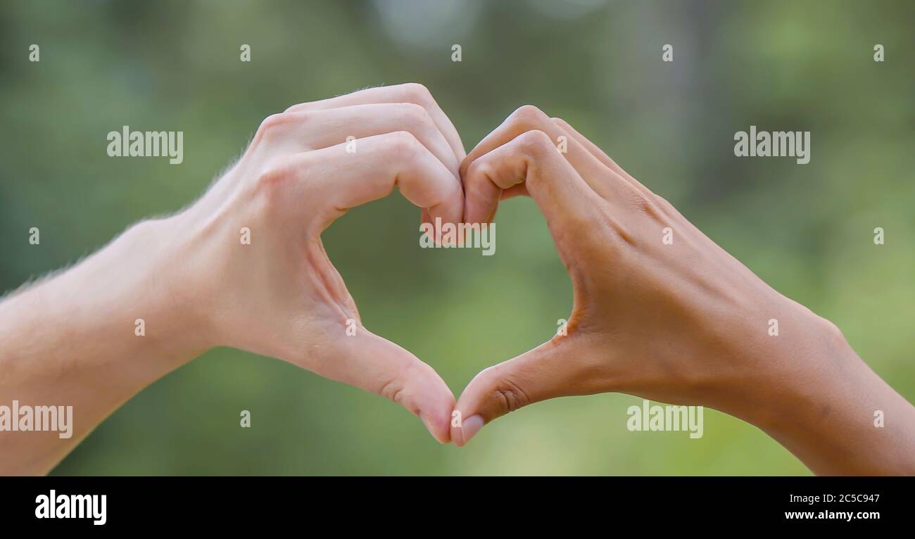 Black and white hands touch a heart - a symbol of anti-racism. 4K stock ...