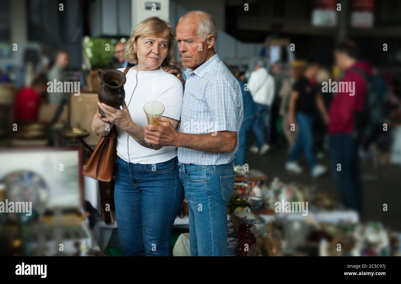 Smiling mature spouses buying retro handicrafts on flea market Stock ...