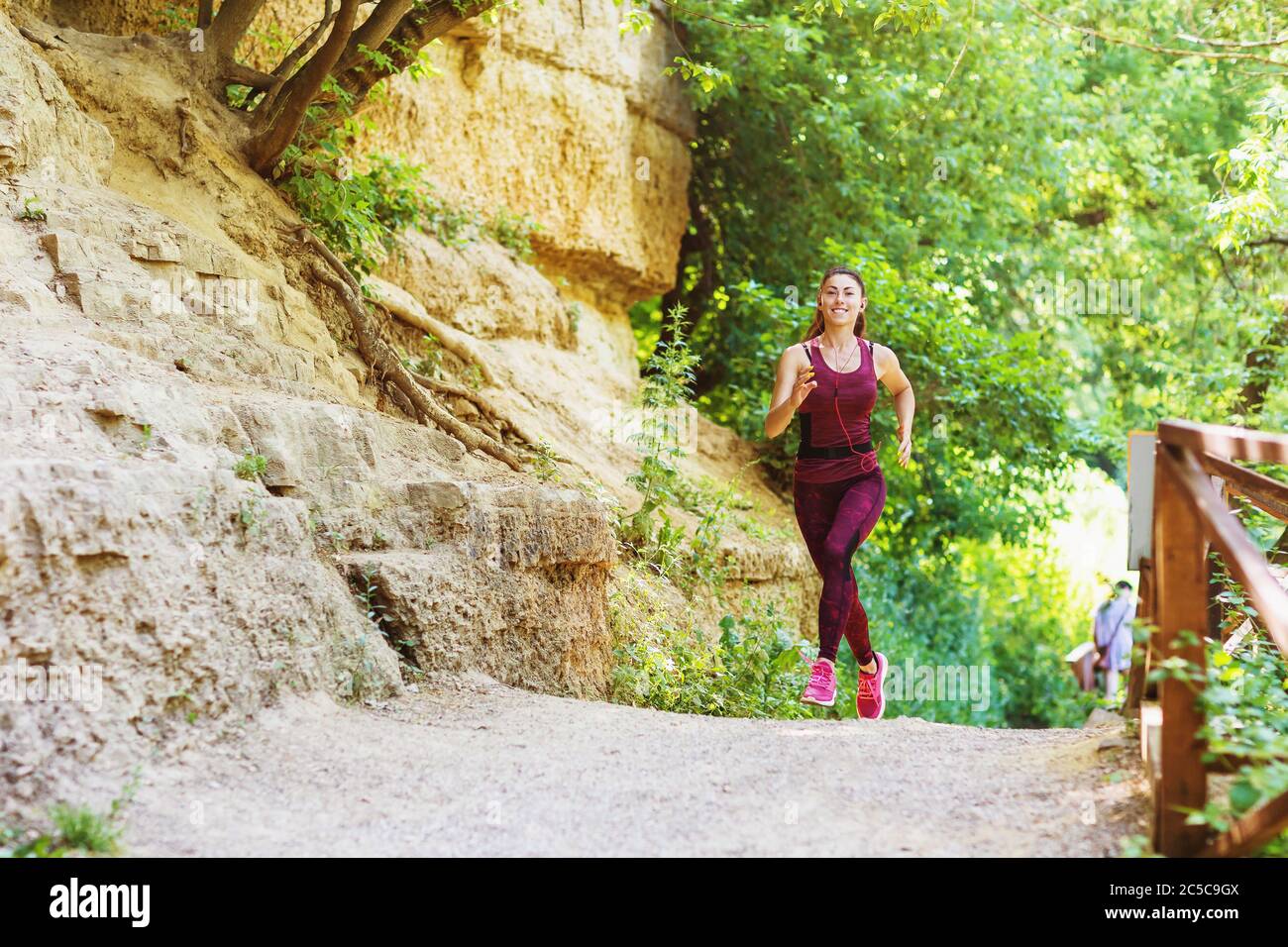 A beautiful sports girl is engaged in morning running in the open air ...