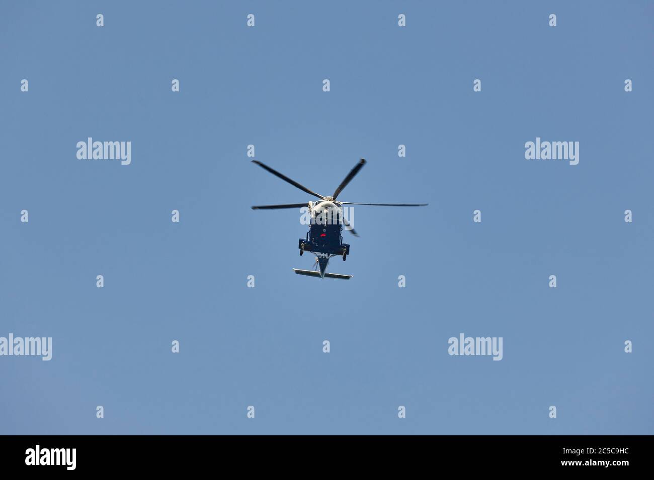 Helicopter flying under a blue sky from below. Air transport Stock ...
