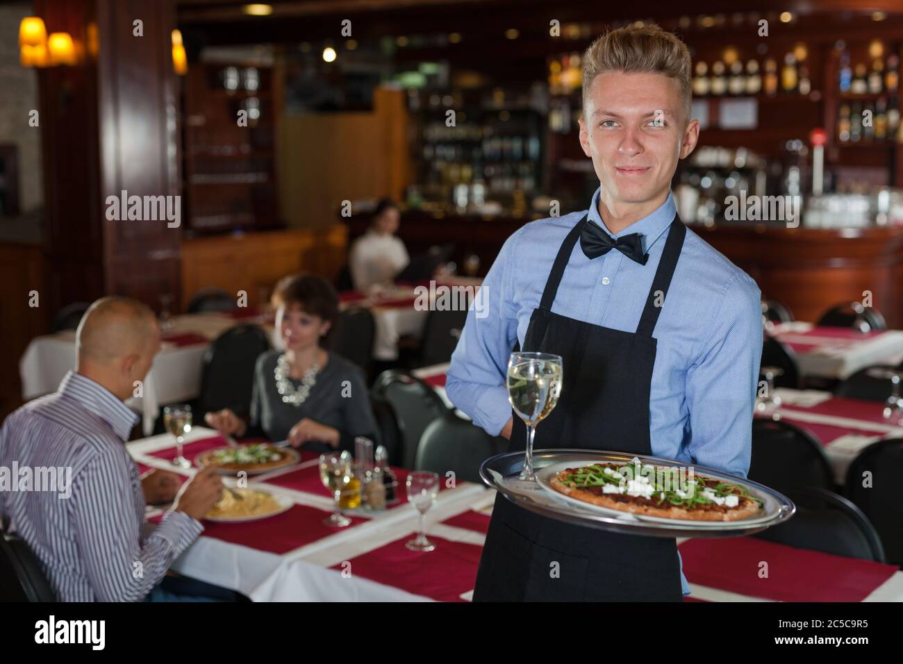 Handsome elegant waiter with serving tray welcoming to restaurant Stock ...