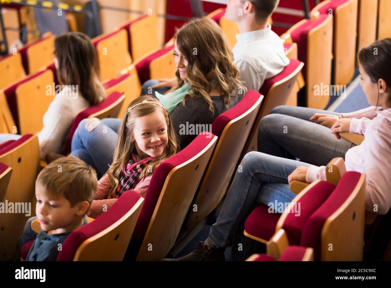 Happy little girl turning around from screen in cinema house Stock ...