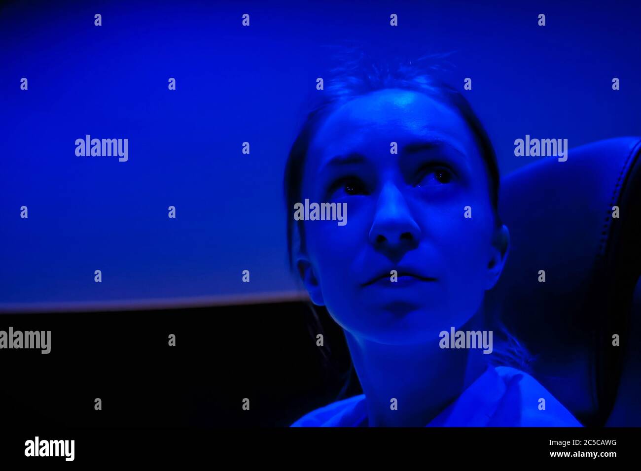 Portrait of woman face looking around in movie theater with panoramic ...