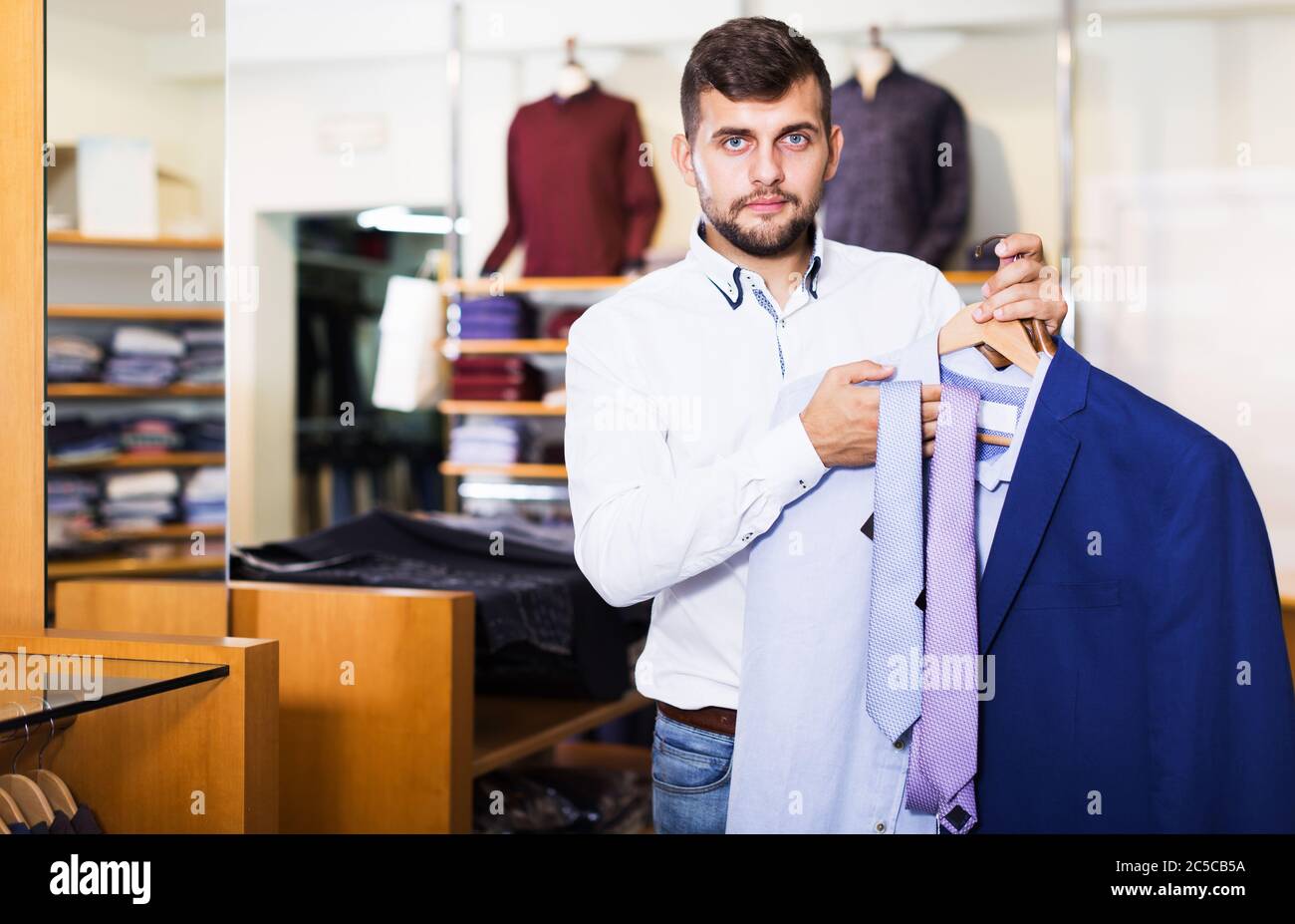 happy russian man choosing casual jacket in fashion store Stock Photo ...