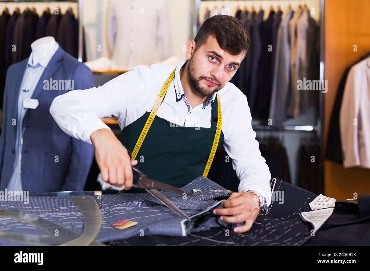 Portrait of busy male tailor in his workplace at workshop Stock Photo ...