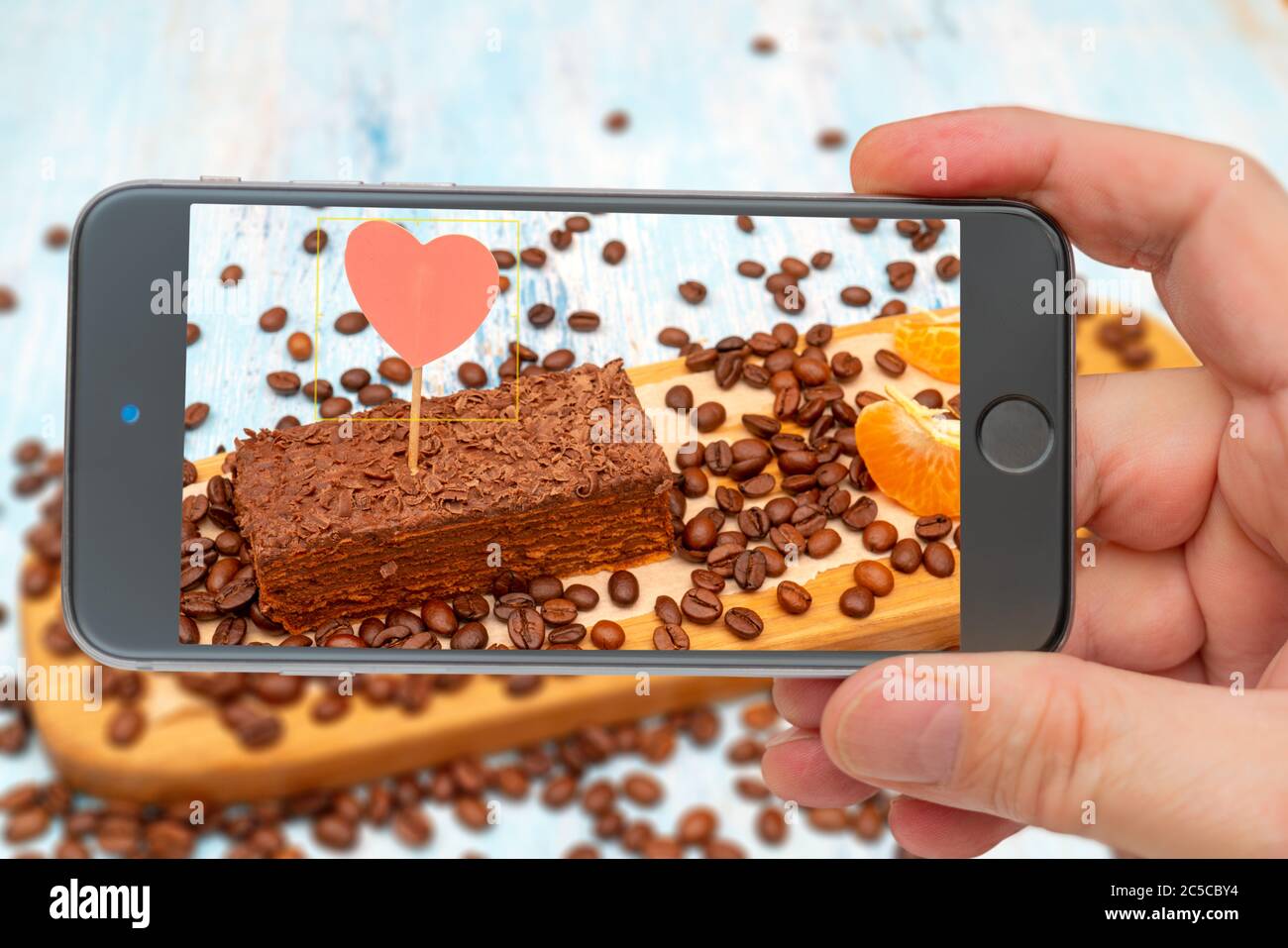 Fresh chocolate cake. Photo smartphone. Smartphone in hand. Cake in the ...