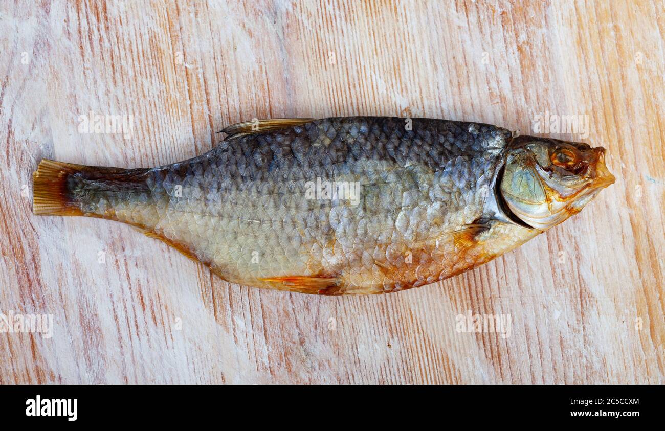 Dried salted roach fish on wooden table, top view Stock Photo - Alamy