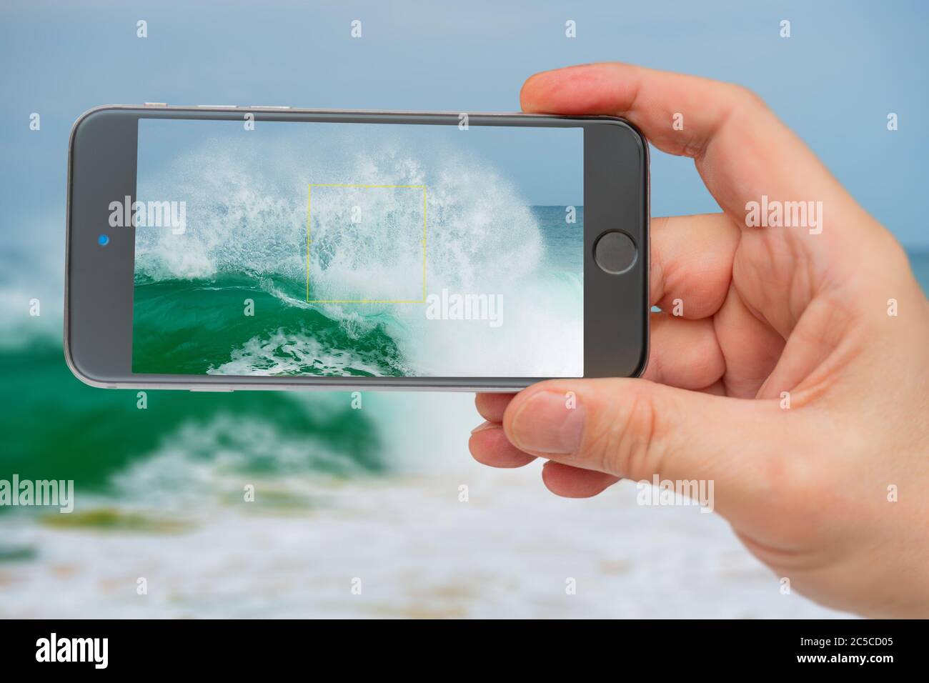 Foam wave running. Photo smartphone. Smartphone in hand. Ocean wave on ...