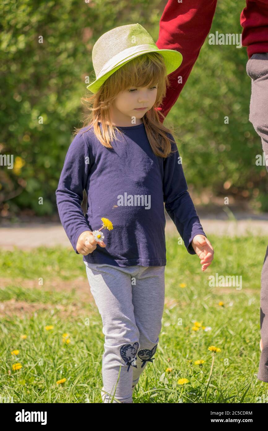 a girl walking in a park with a hat on her head Stock Photo - Alamy