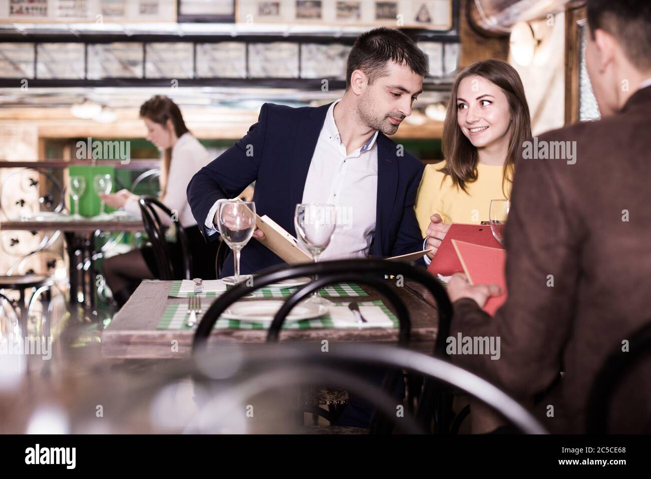 Couple with menu is choosing order in time dinner in restaurant Stock ...