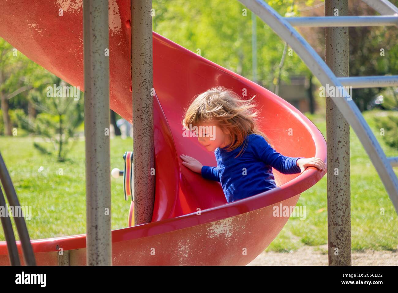 Girl coming down the slide in the park Stock Photo - Alamy