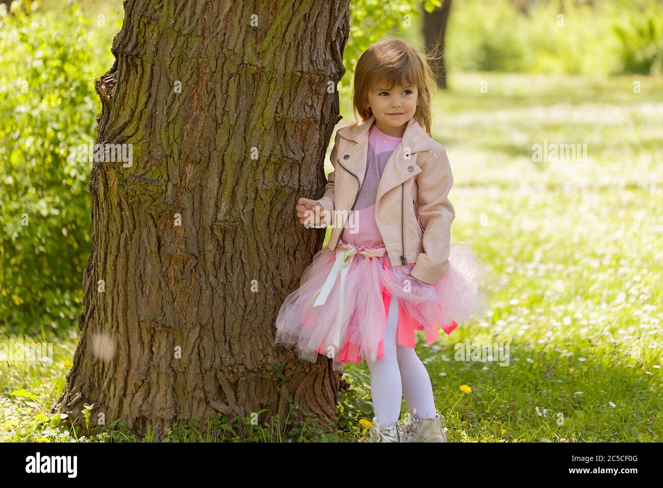 the girl poses next to the tree Stock Photo - Alamy