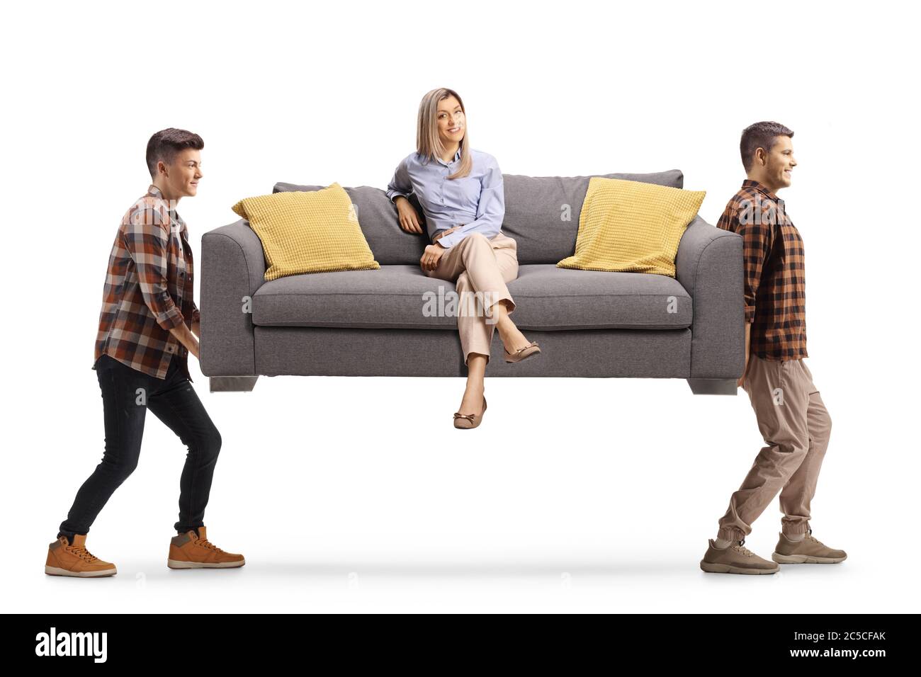 Two guys carrying a sofa with a woman sitting on it isolated on white ...