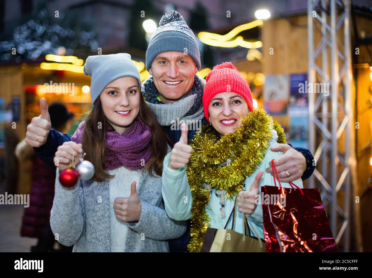 Happy glad family of three posing at Christmas market Stock Photo - Alamy