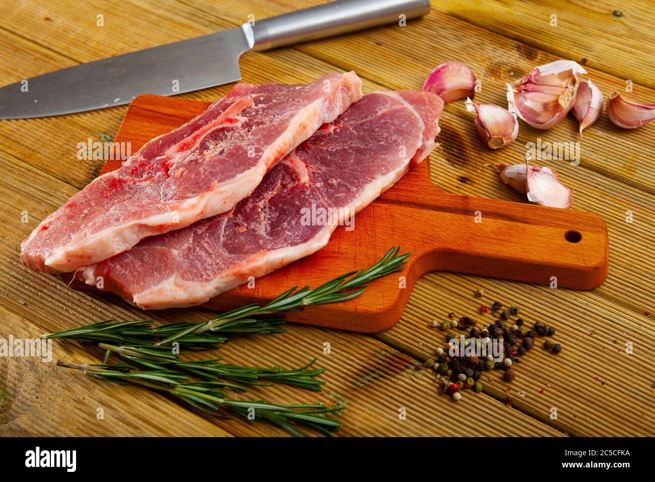 Home cooking. Pieces of fresh raw pork shoulder and condiments prepared ...