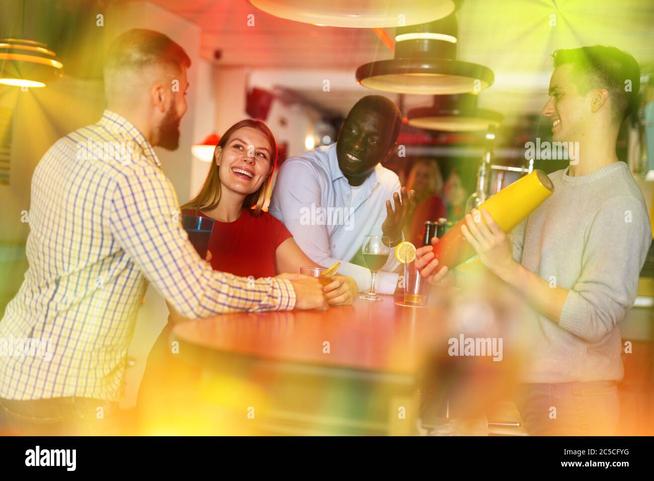 Smiling people talking with drinks in the hand in the nightclub Stock ...