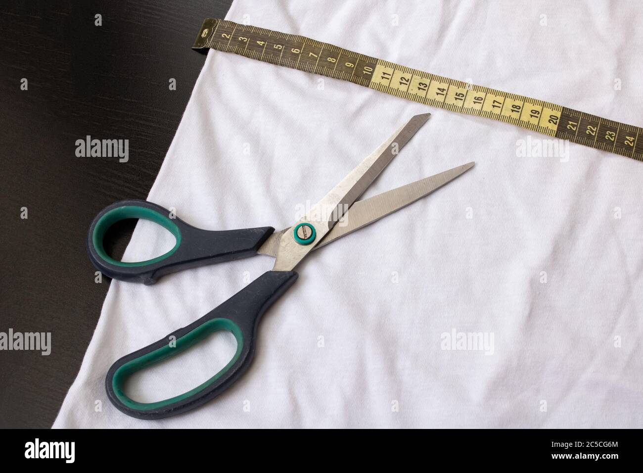 Measuring tape and scissors on white fabric Stock Photo - Alamy