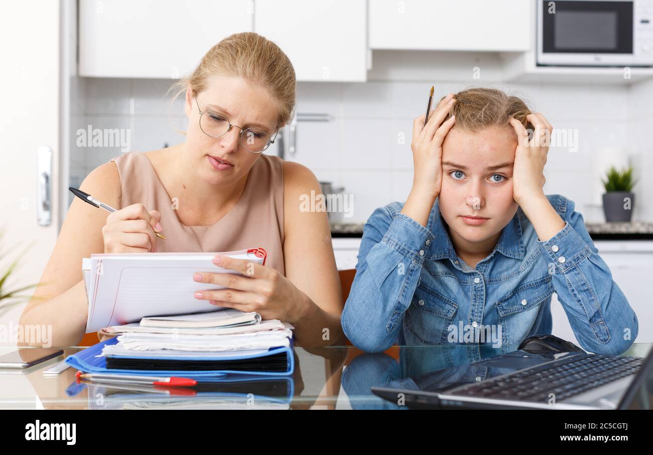 Strict mother checking poorly done home task of her daughter at kitchen ... Strict mother checking poorly done home task of her daughter at kitchen ...