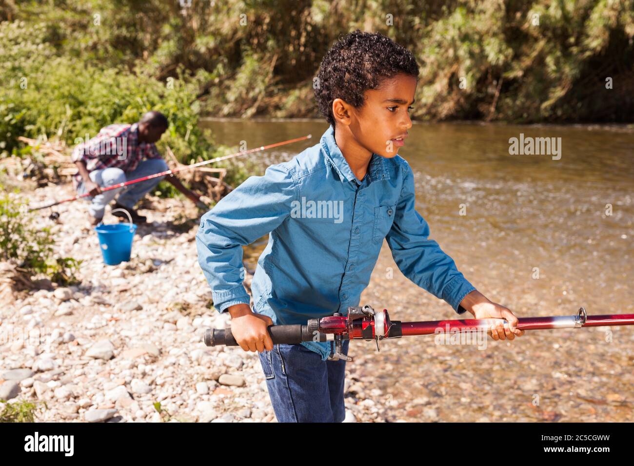 Little African boy fishing with his father and pulling fish Stock Photo ...