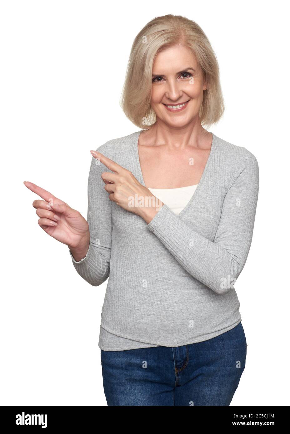 Portrait of casual smiling old woman pointing finger to copy space ...
