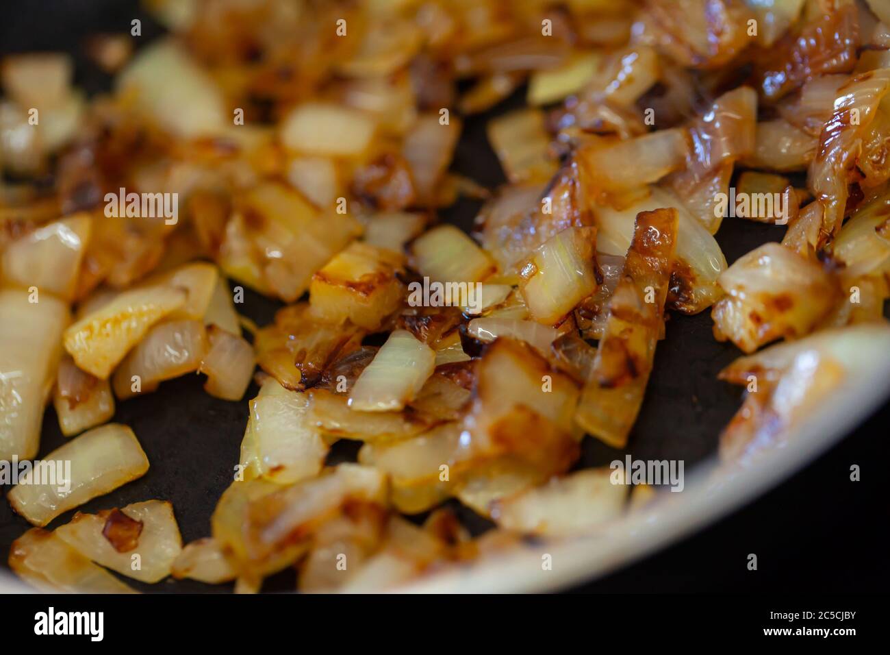 Fried onions in a frying pan. Roasting the chopped onion in oil Stock ...