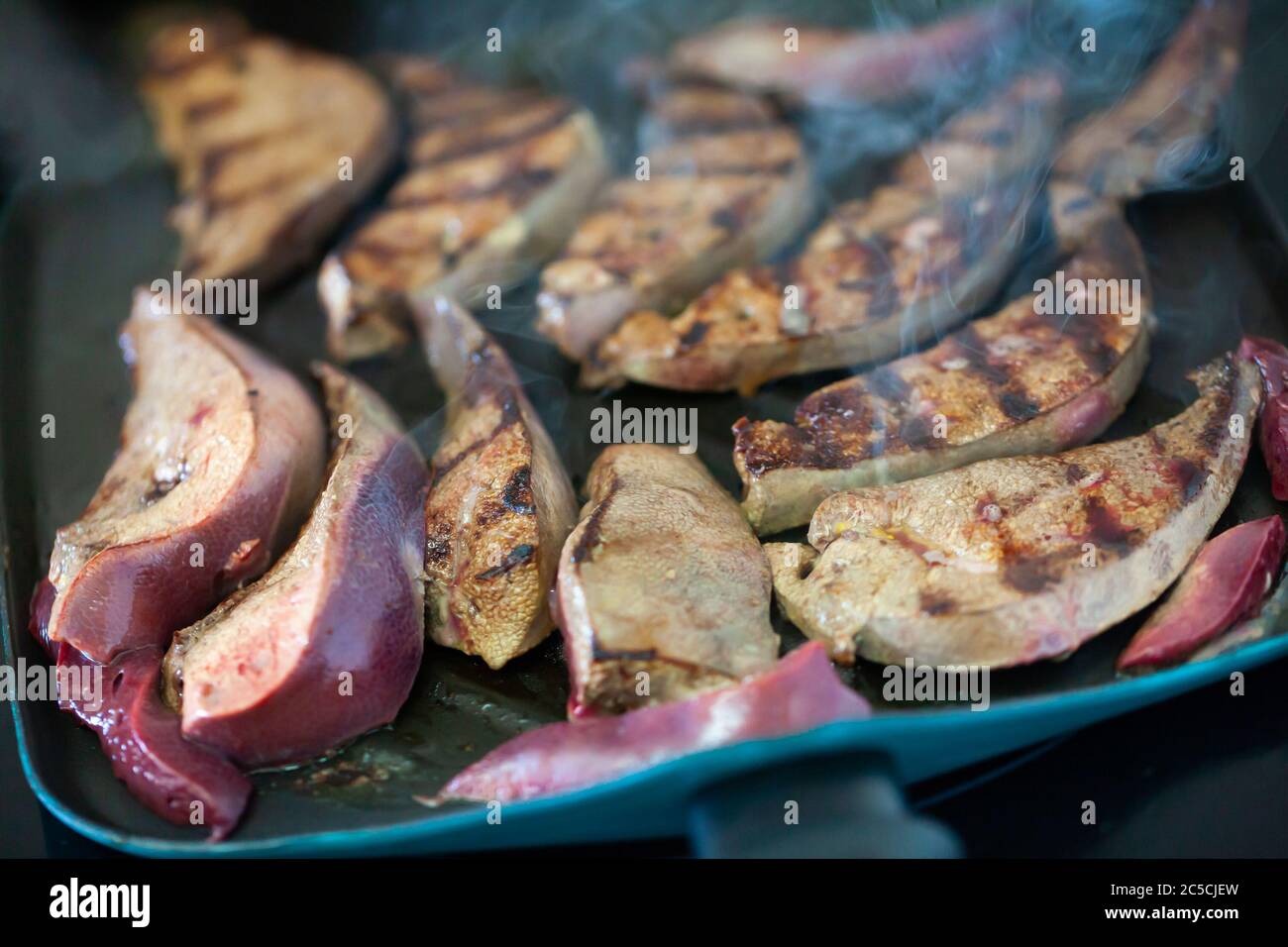 Pork liver on grill frying pan, food preparation Stock Photo - Alamy