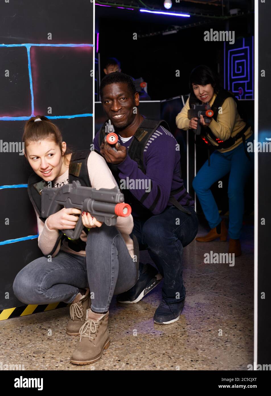 Two lucky laser tag players of different nationalities aiming laser ...