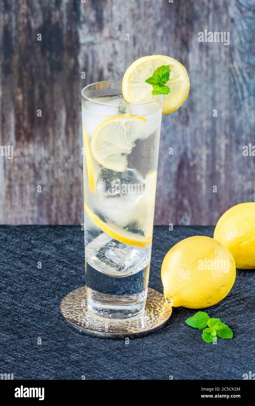 Water with lemon and ice cubes garnished with a slice of lemon and mint ...