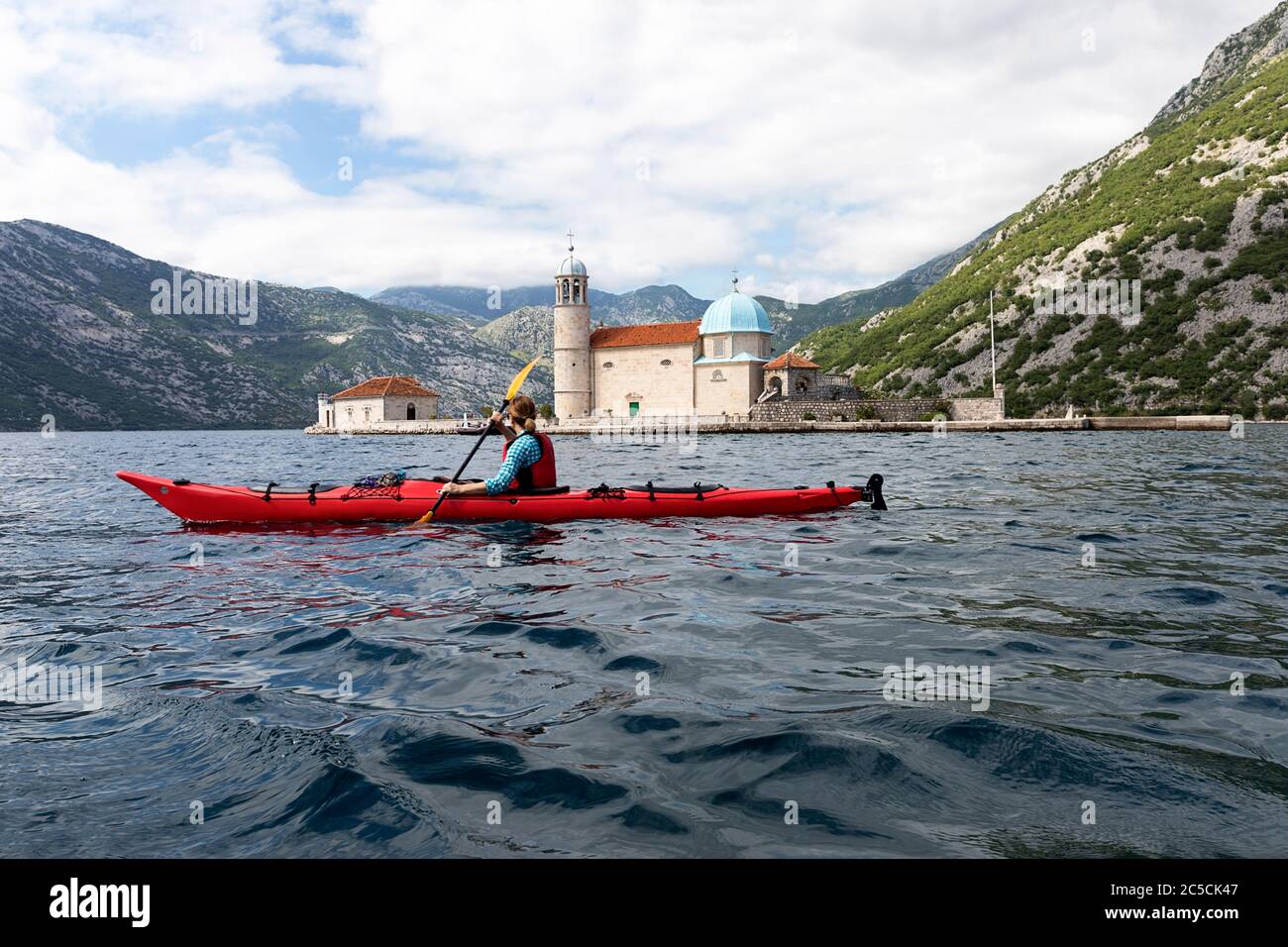 woman kayaking in red kayak around the island Our Lay of the rocks ...