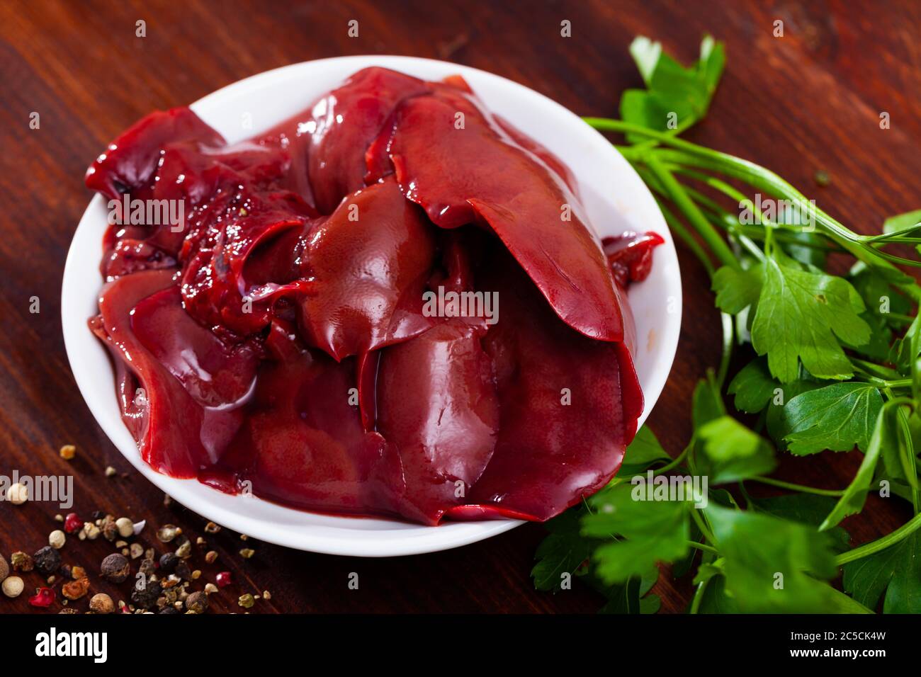 Image of raw rabbit liver with garlic and greens during cooking Stock ...