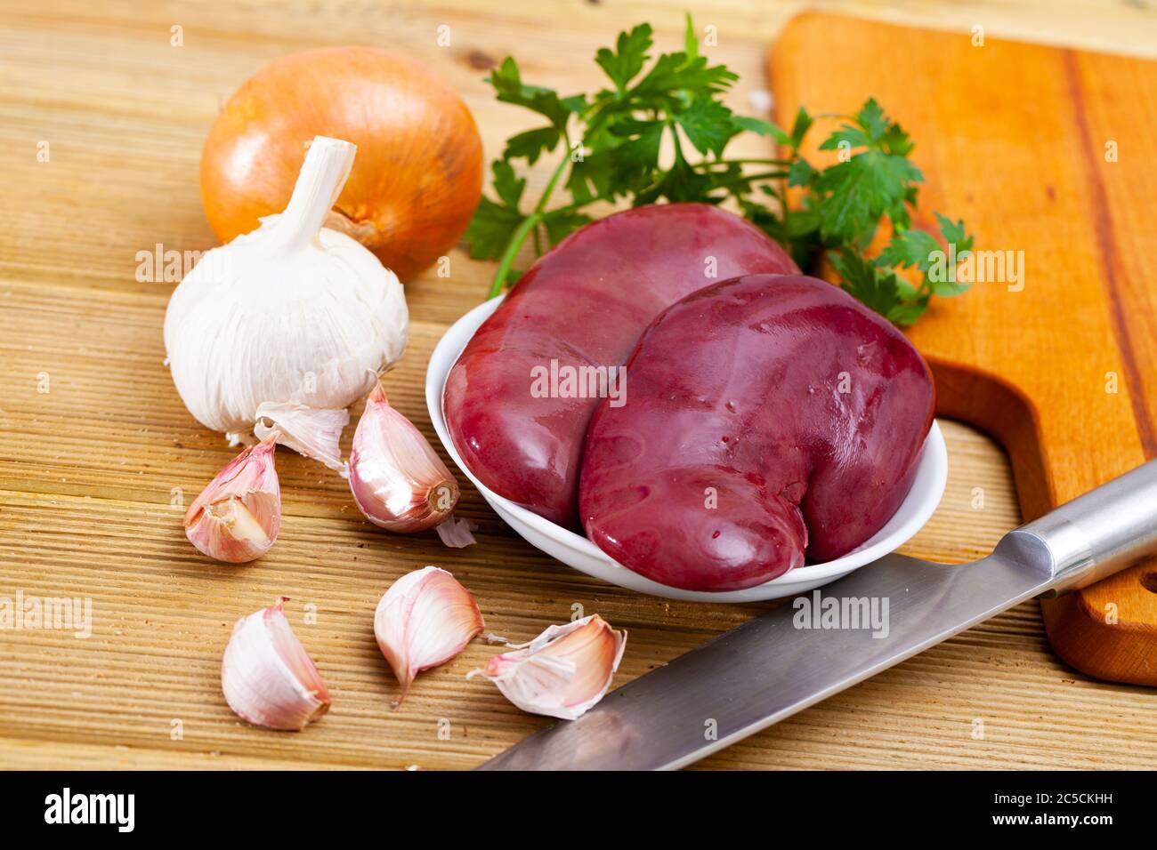 Fresh raw pork kidneys with seasonings on wooden background. Home ...