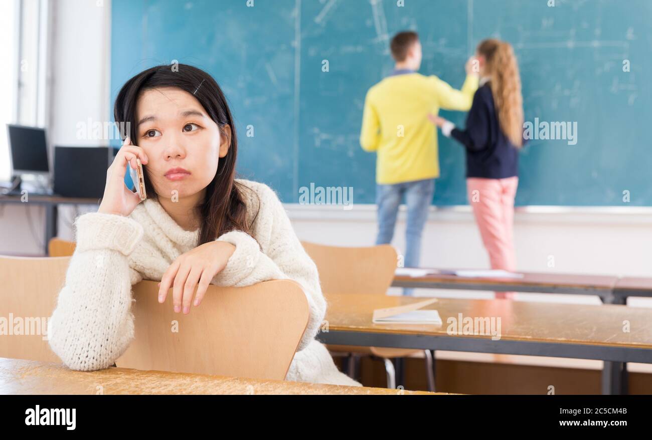 Portrait of unhappy female chinese student in auditorium, students ...