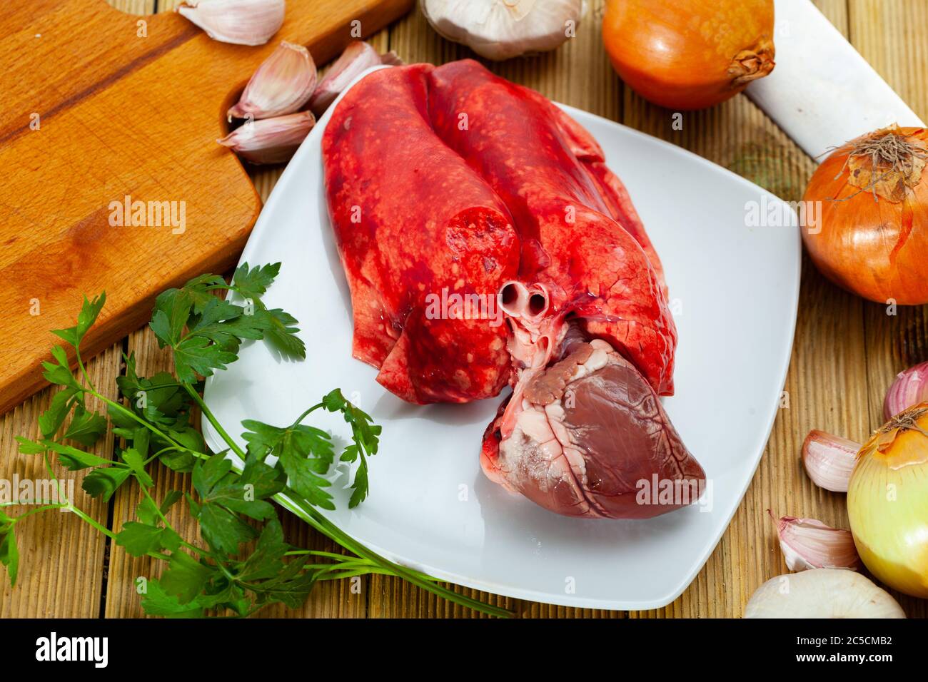 Image of raw lamb lungs and heart served with greens during cooking ...
