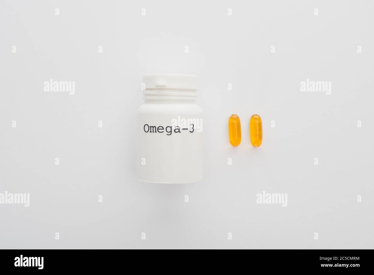 Top view of container with omega-3 lettering and yellow capsules on ...