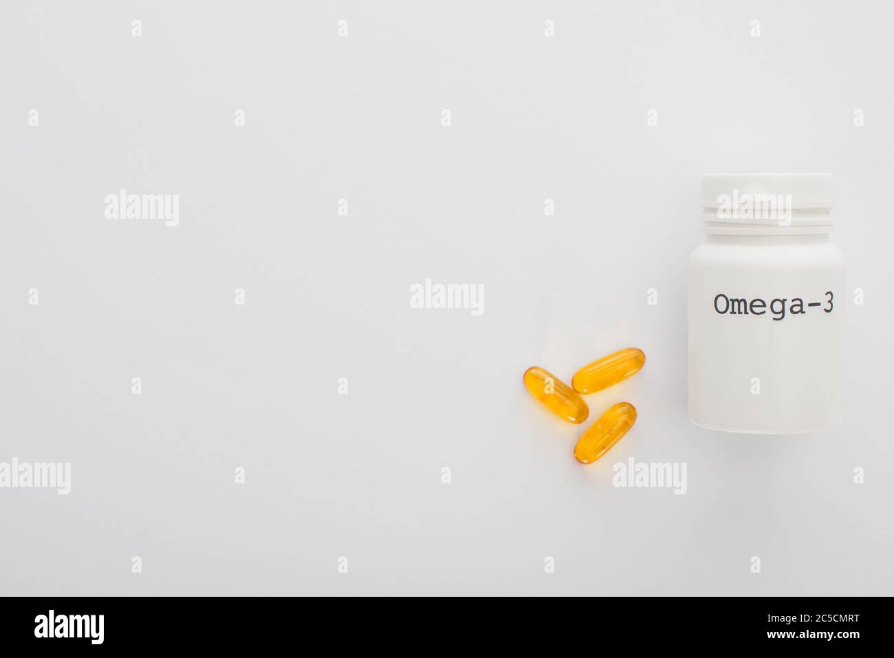 Top view of container with omega-3 lettering and capsules on white ...
