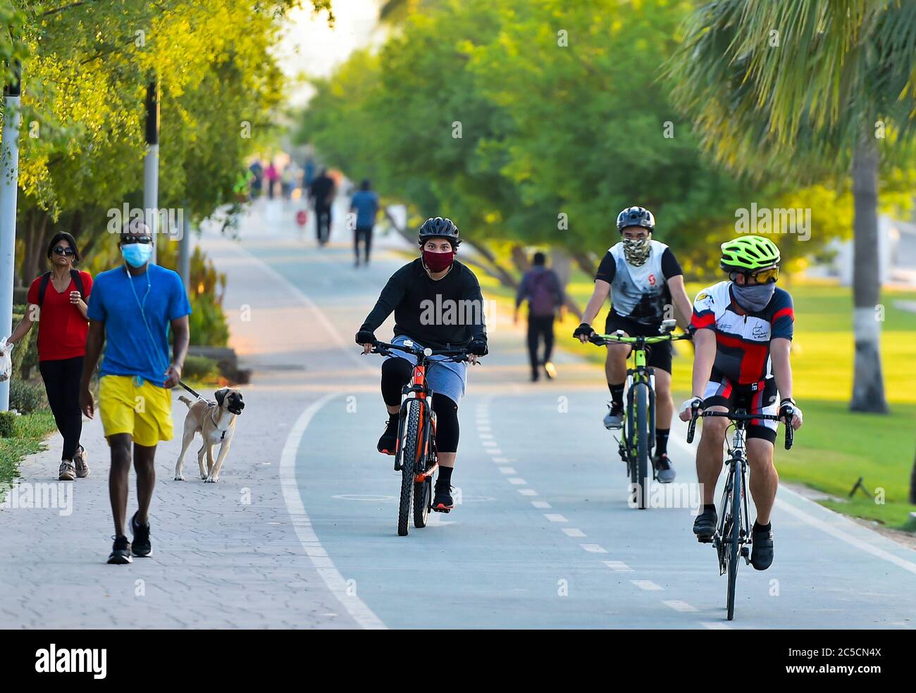 Doha, Qatar. 1st July, 2020. People wearing face masks walk and cycle ...