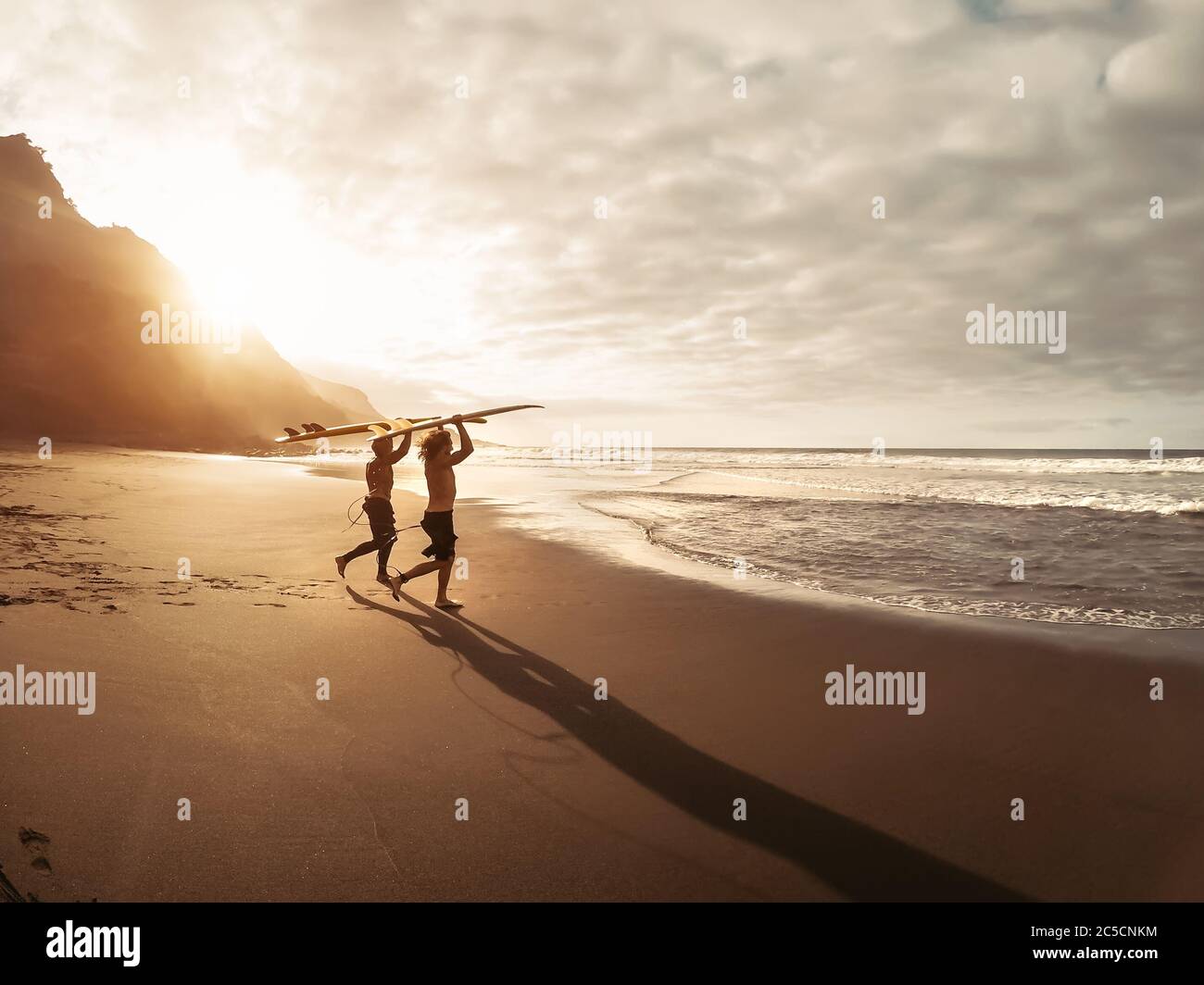 Happy friends surfing together on tropical ocean - Sporty people having ...