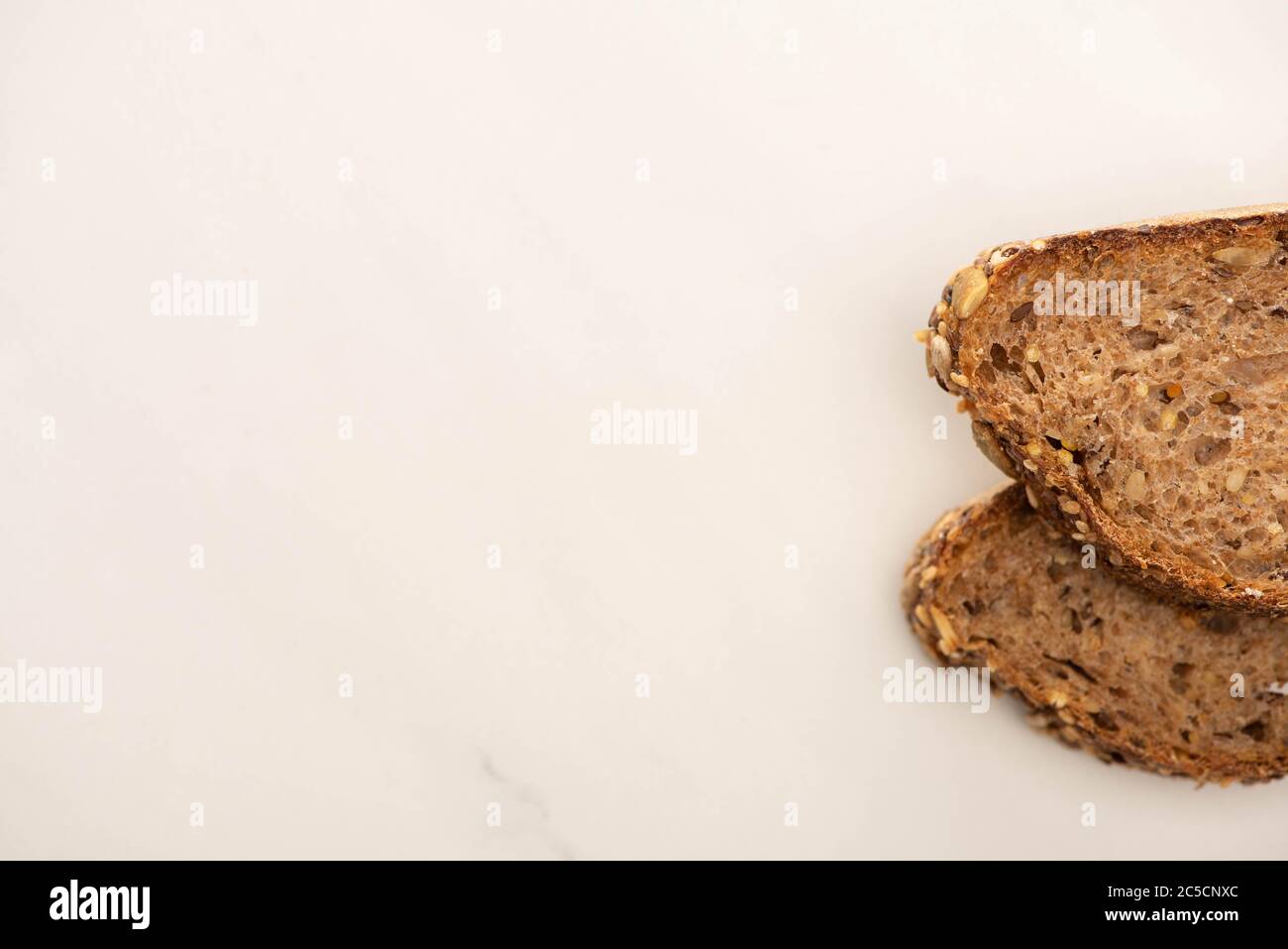 top view of fresh brown bread slices on white background Stock Photo ...