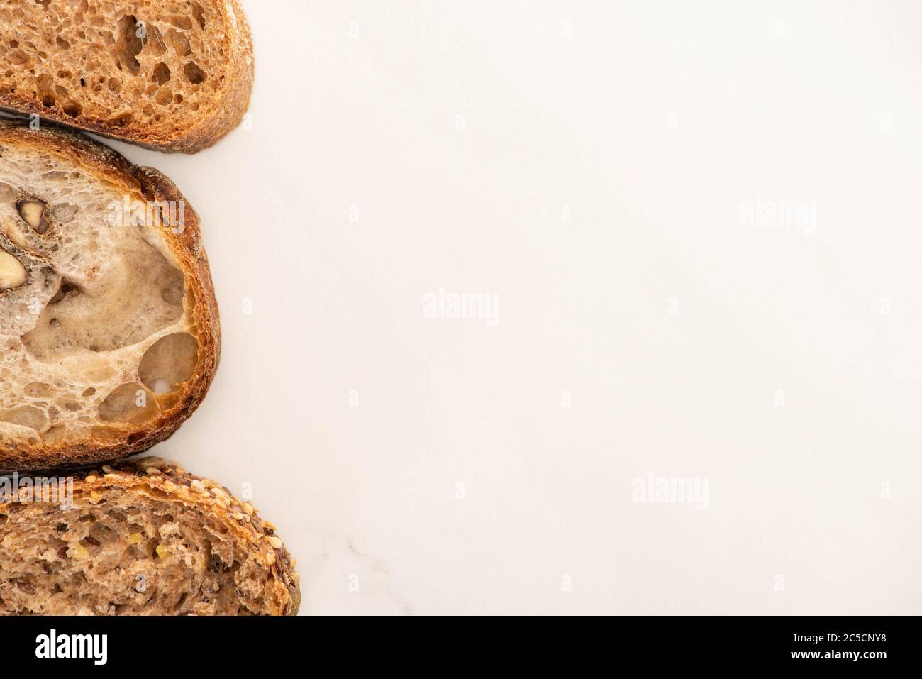 top view of whole wheat bread slices on white background with copy ...