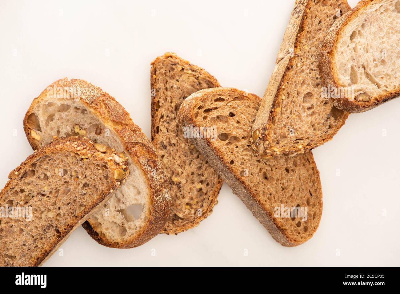 top view of fresh whole grain bread slices on white background Stock Photo - Alamy