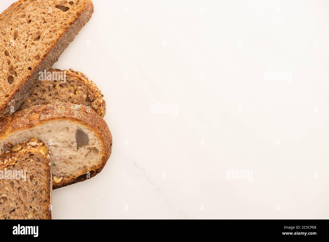 top view of fresh whole grain bread slices on white background with ...