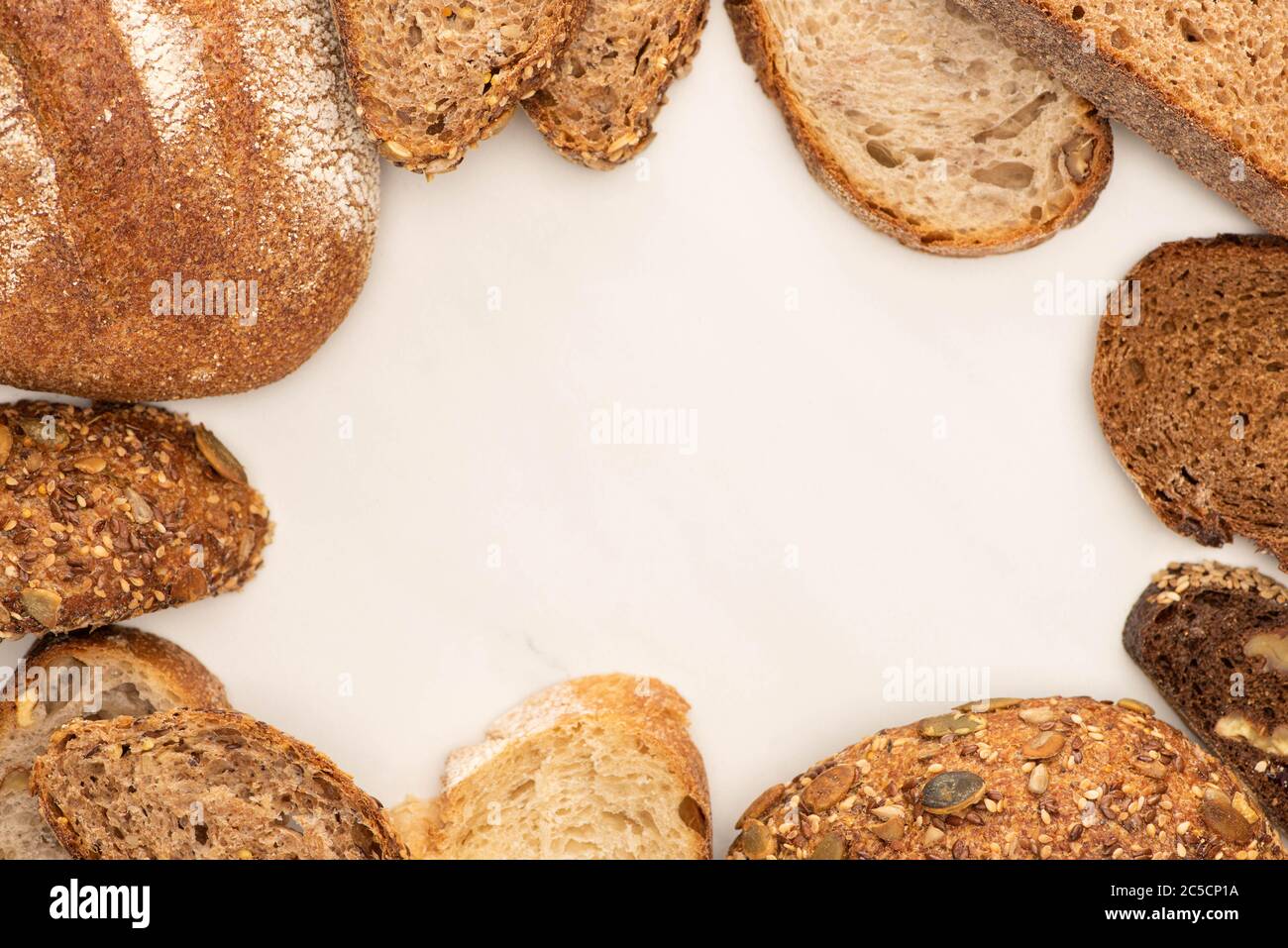 top view of fresh brown bread slices and loaves on white background ...