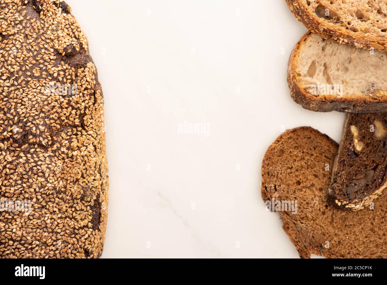 top view of fresh whole grain bread slices and loaf on white background ...