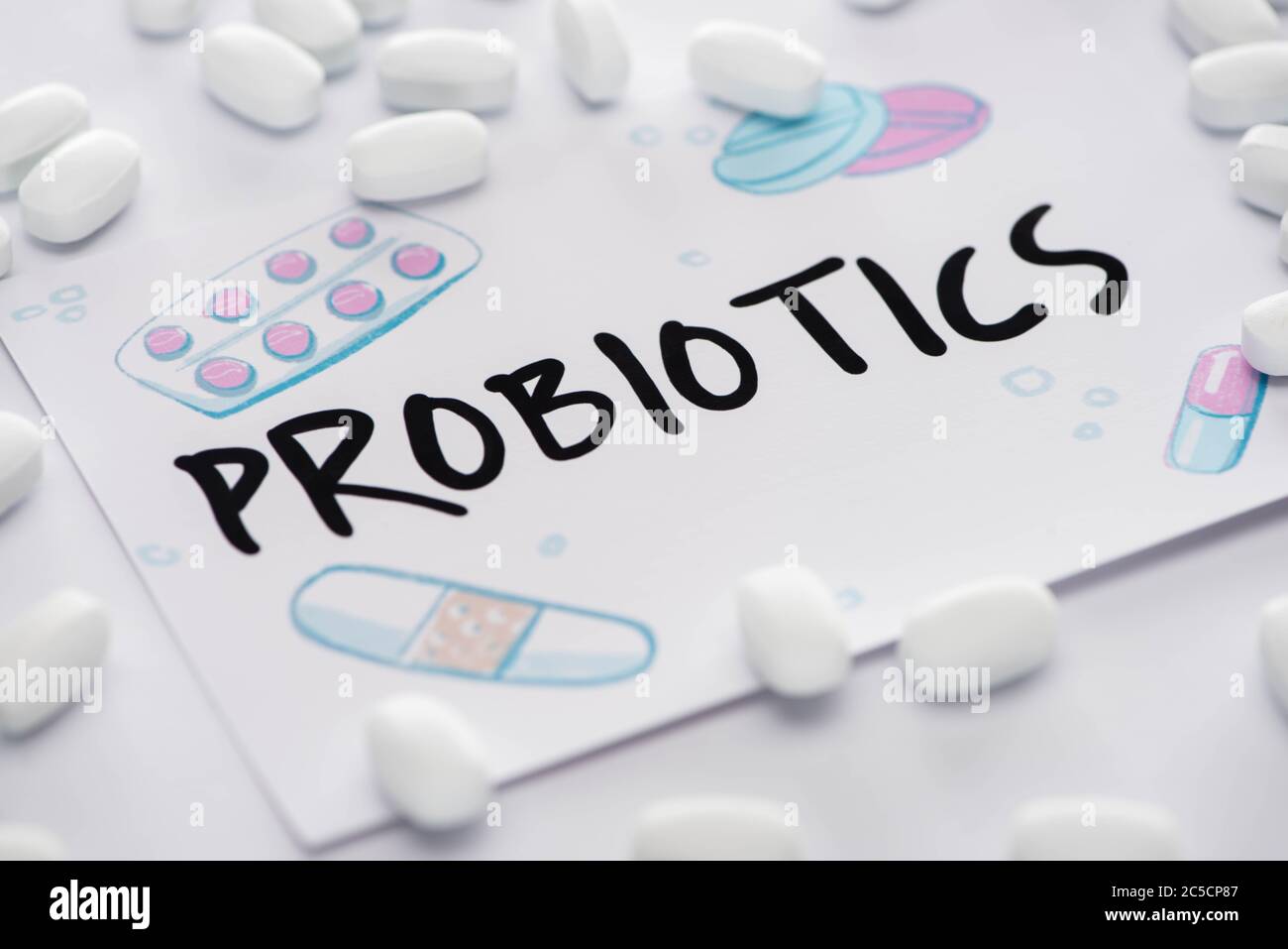 selective focus of drawing with probiotics lettering near pills on ...