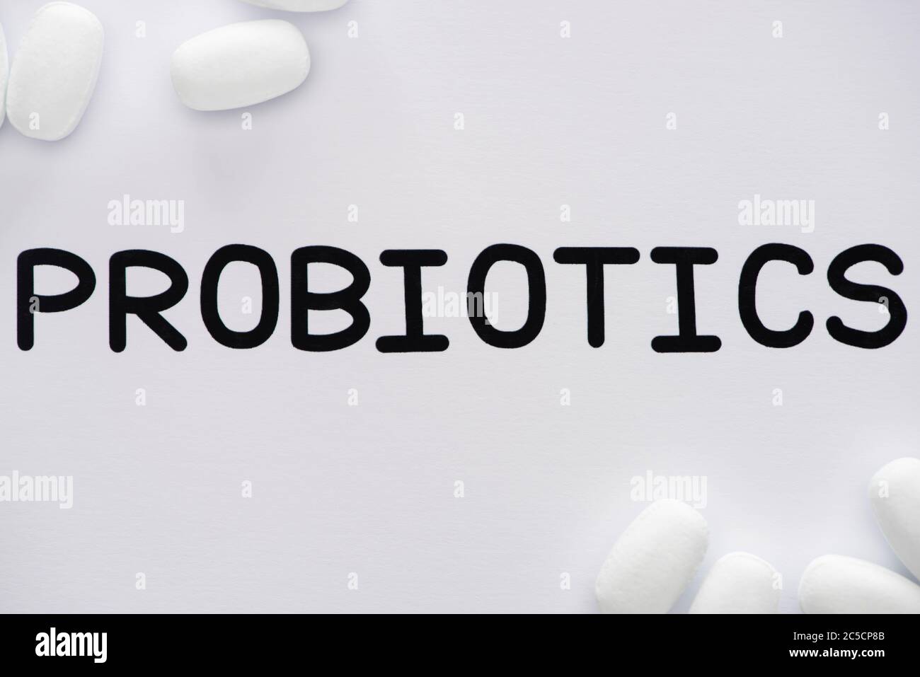top view of paper with probiotics lettering and pills on white ...