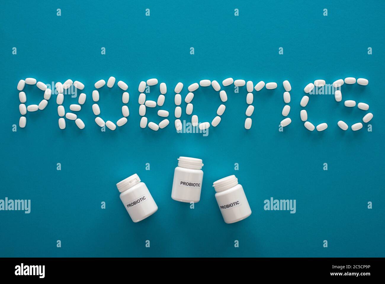 top view of probiotics lettering made of pills and containers on blue ...