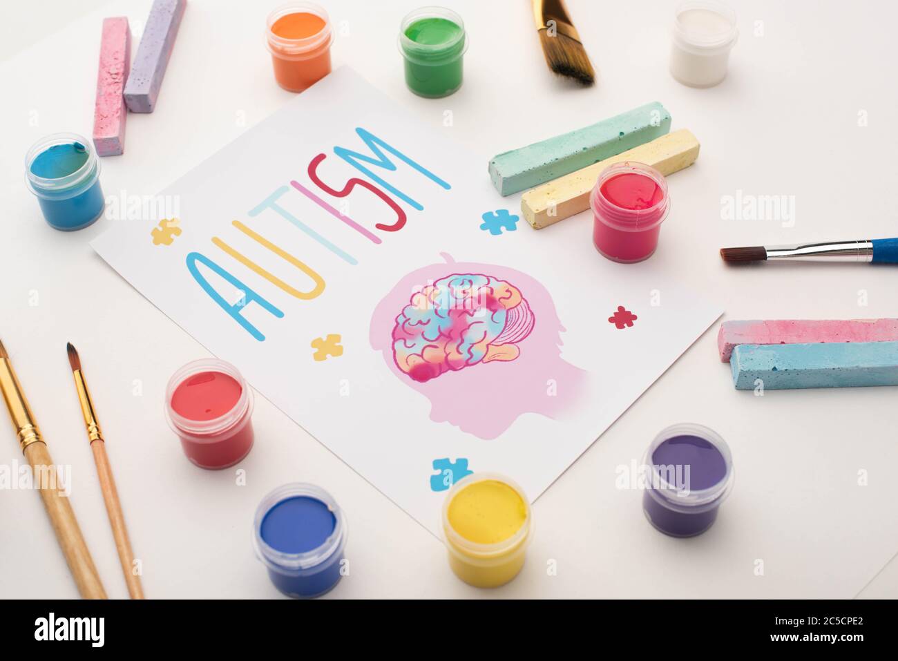 card with autism word and painting of head with brain and puzzle on ...