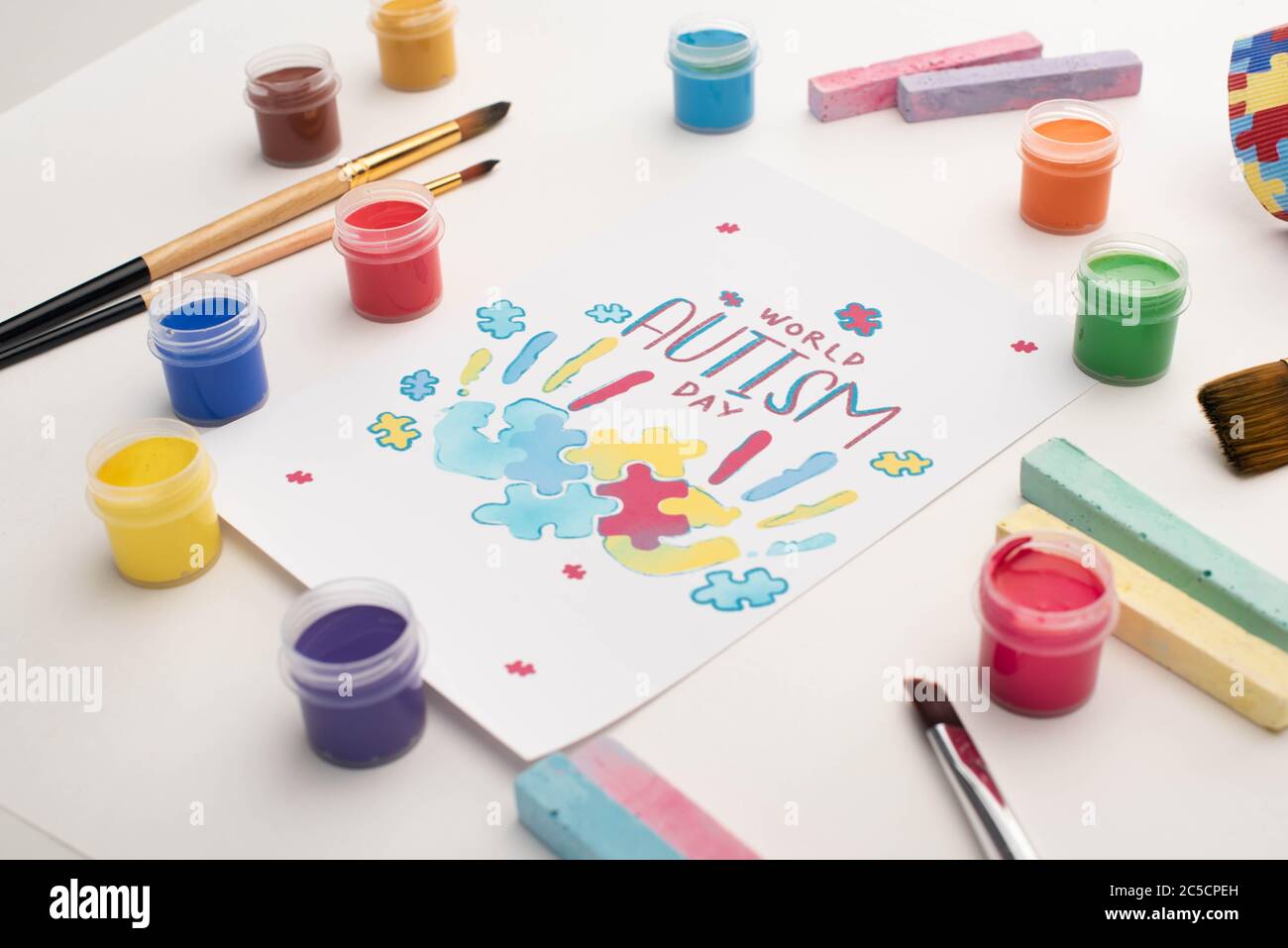 card with World Autism Day lettering and painting of puzzle and hand ...