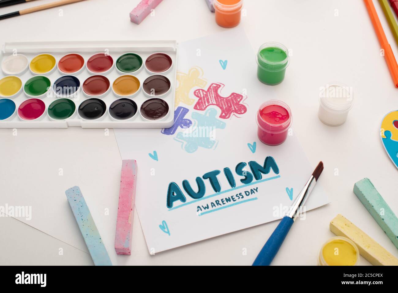card with Autism Awareness Day lettering and painting of puzzle on ...
