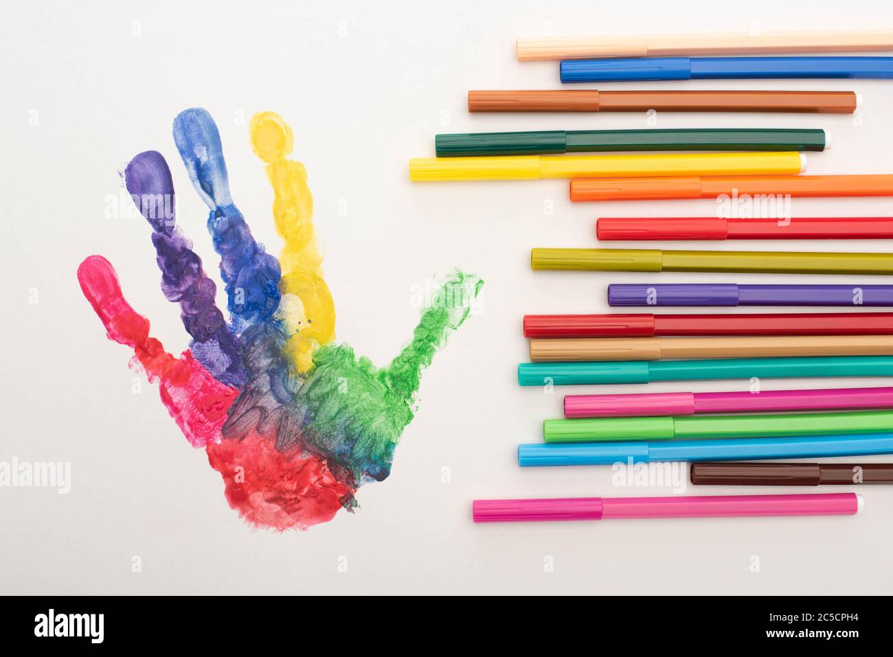 top view of colorful handprint and markers on white for World Autism ...